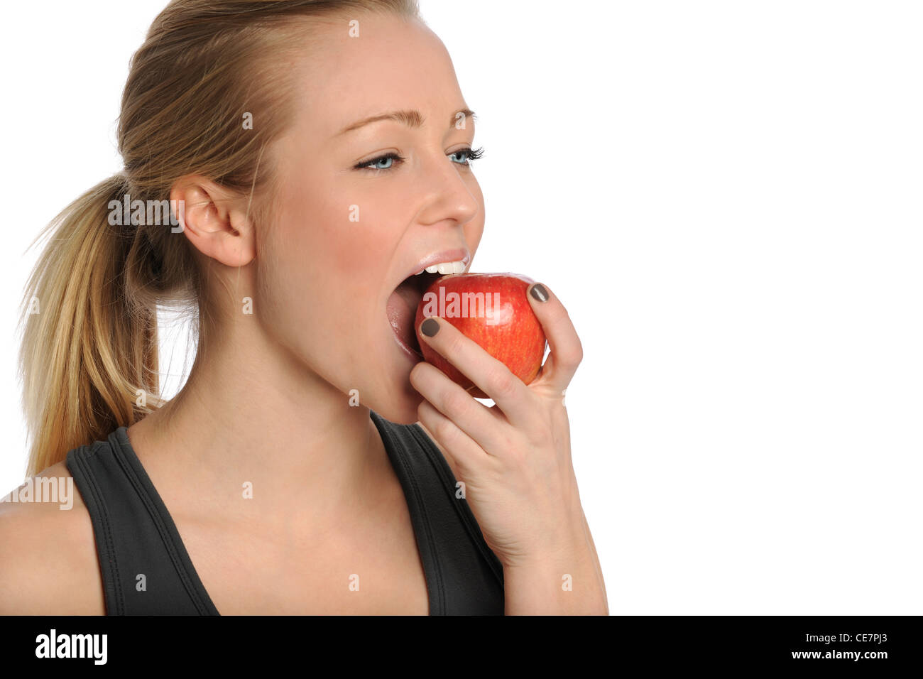 Portrait of beautiful young woman eating red apple isolated over white ...