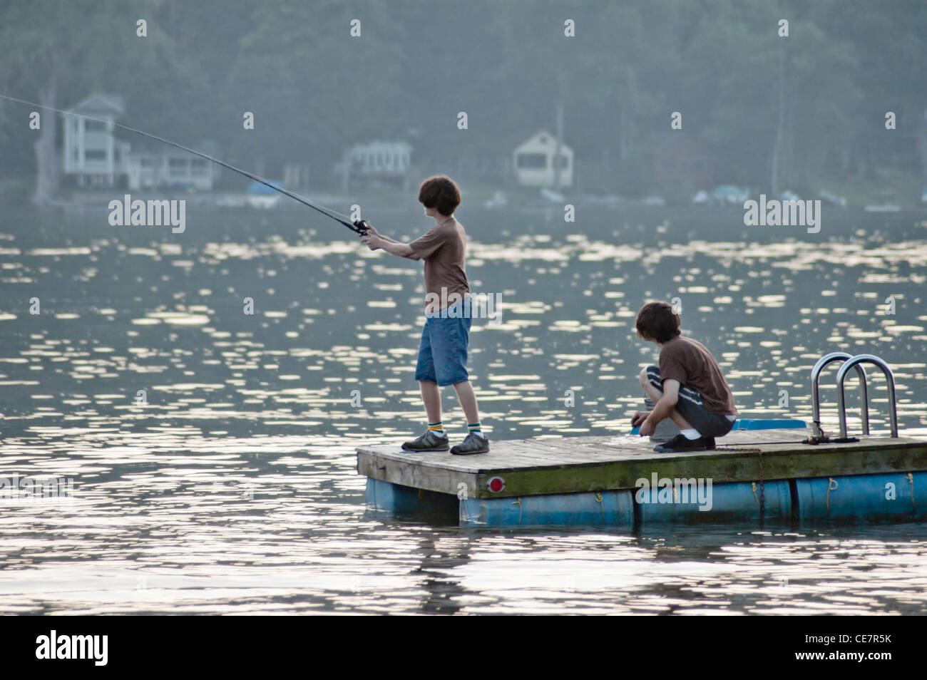 two boys fishing off a dock during summer vacation Stock Photo - Alamy
