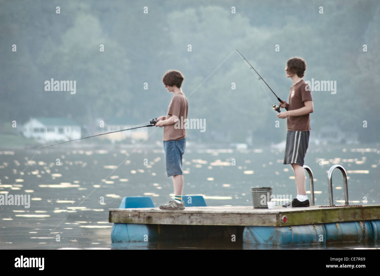 two boys fishing off a dock during summer vacation Stock Photo - Alamy