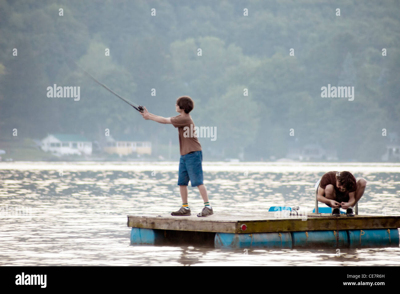 two boys fishing off a dock during summer vacation Stock Photo - Alamy