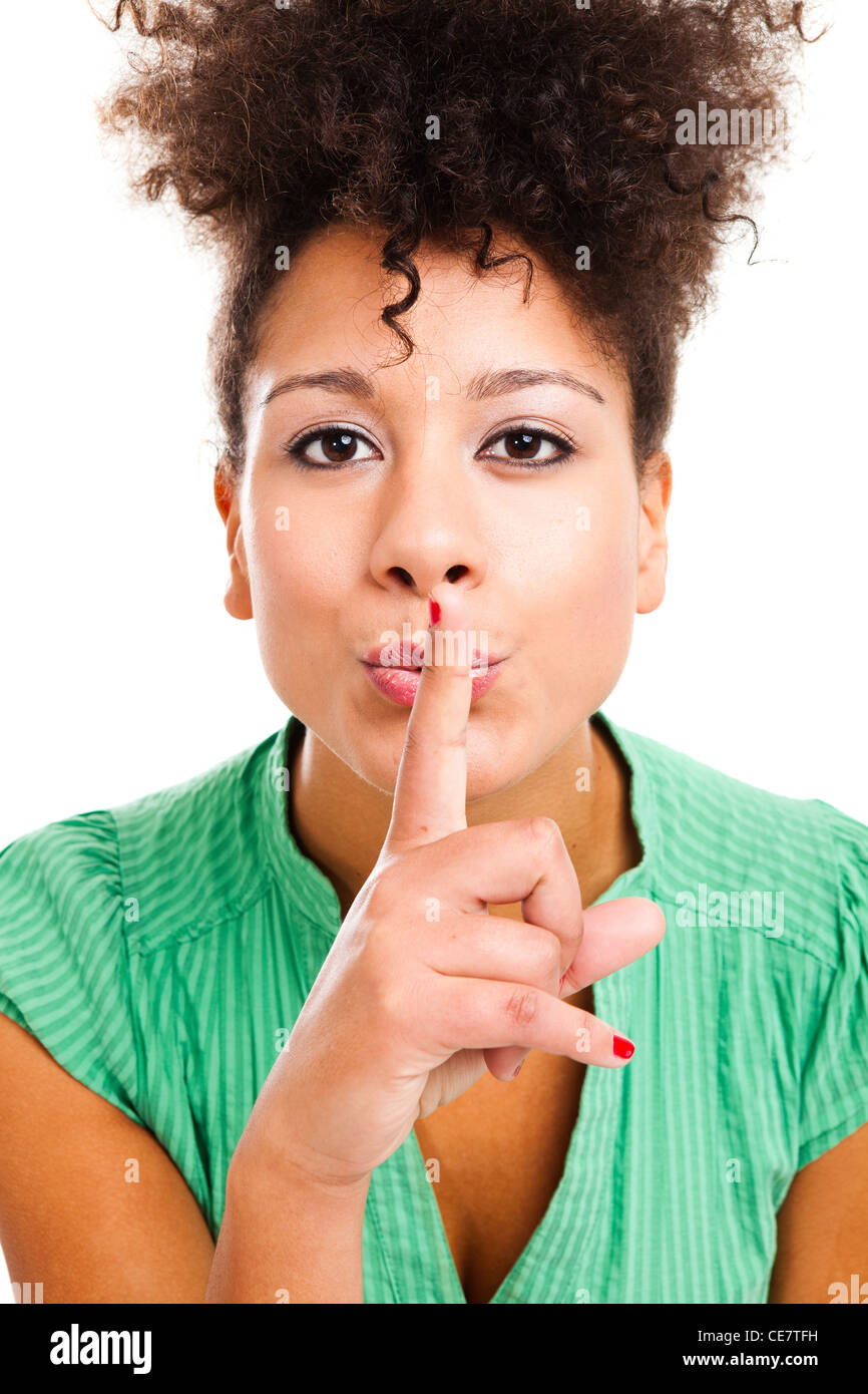 Beautiful young woman hushing with finger on lips. Studio shot with ...
