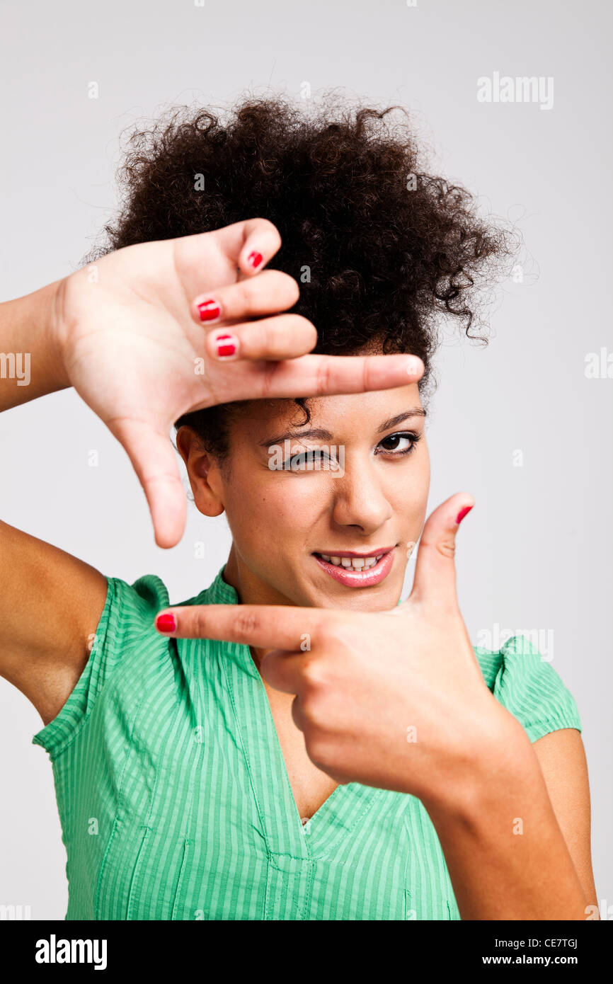 Beautiful woman making a frame with fingers in front of face. Studio ...