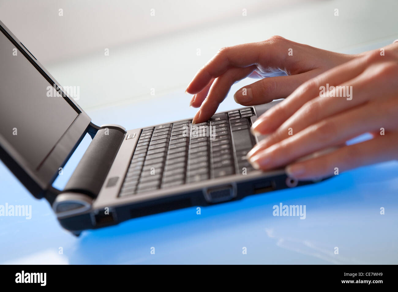 Woman's hand gently enters data in a laptop Stock Photo - Alamy