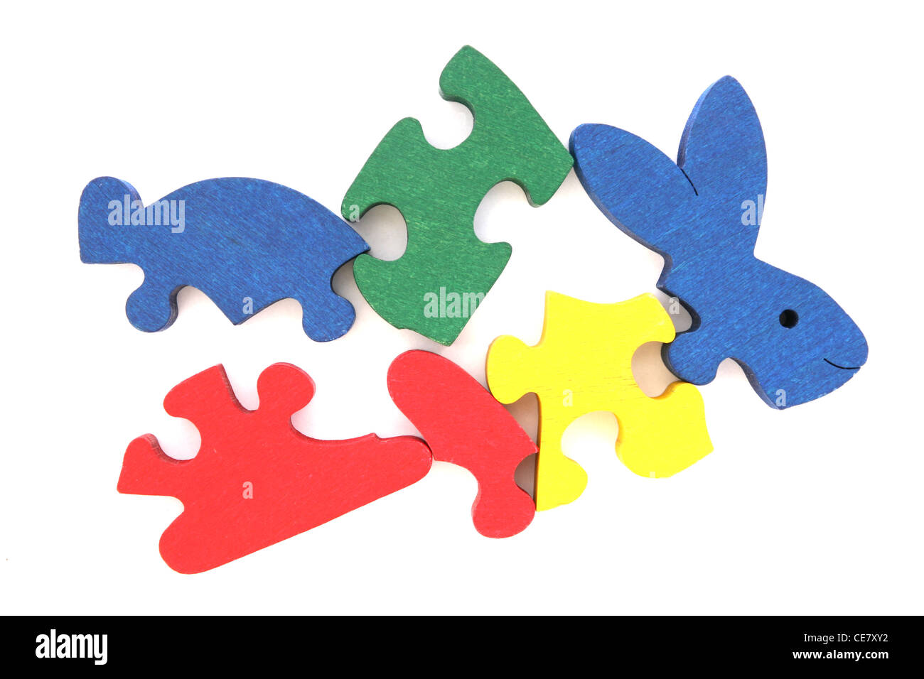 Colorful wooden rabbit puzzle toy partially scattered on white ...