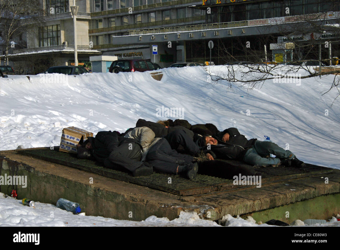 Homeless people sleeping on a warm air vent in Moscow, Russia Stock ...