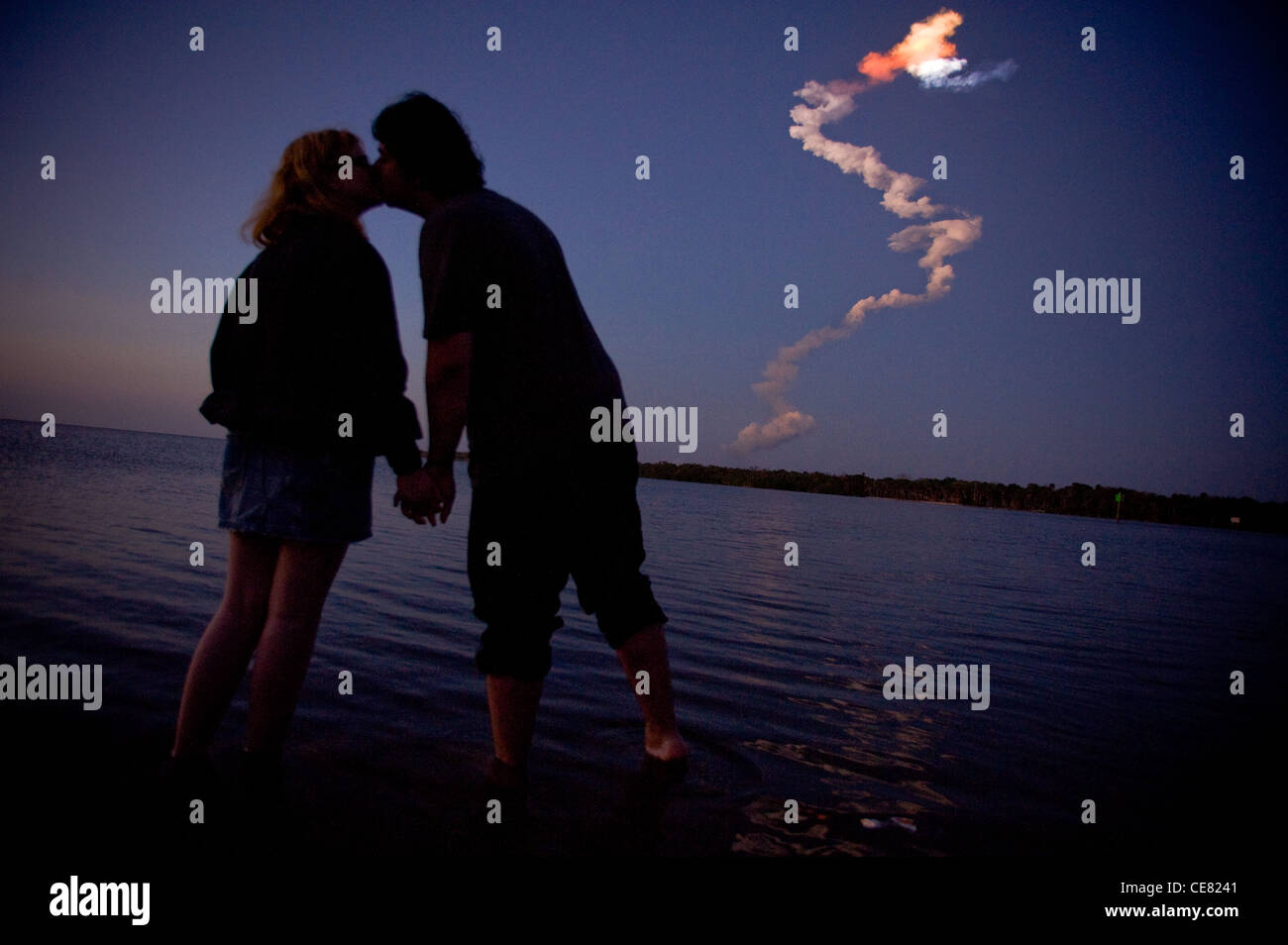 A couple is seen in the Indian River while the Space Shuttle orbiter ...
