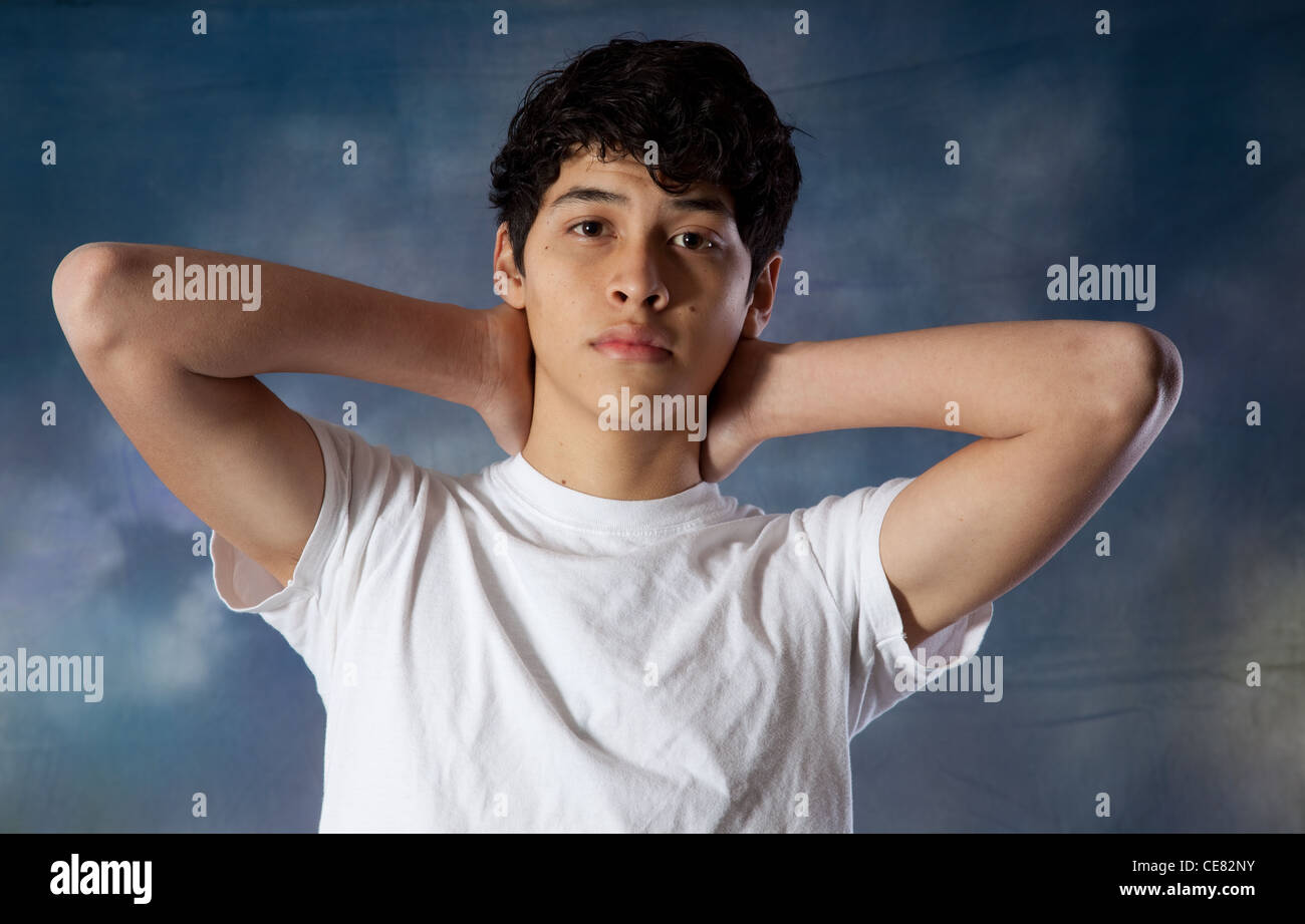 Young teenage Hispanic boy in a T-shirt and a serious expression ...