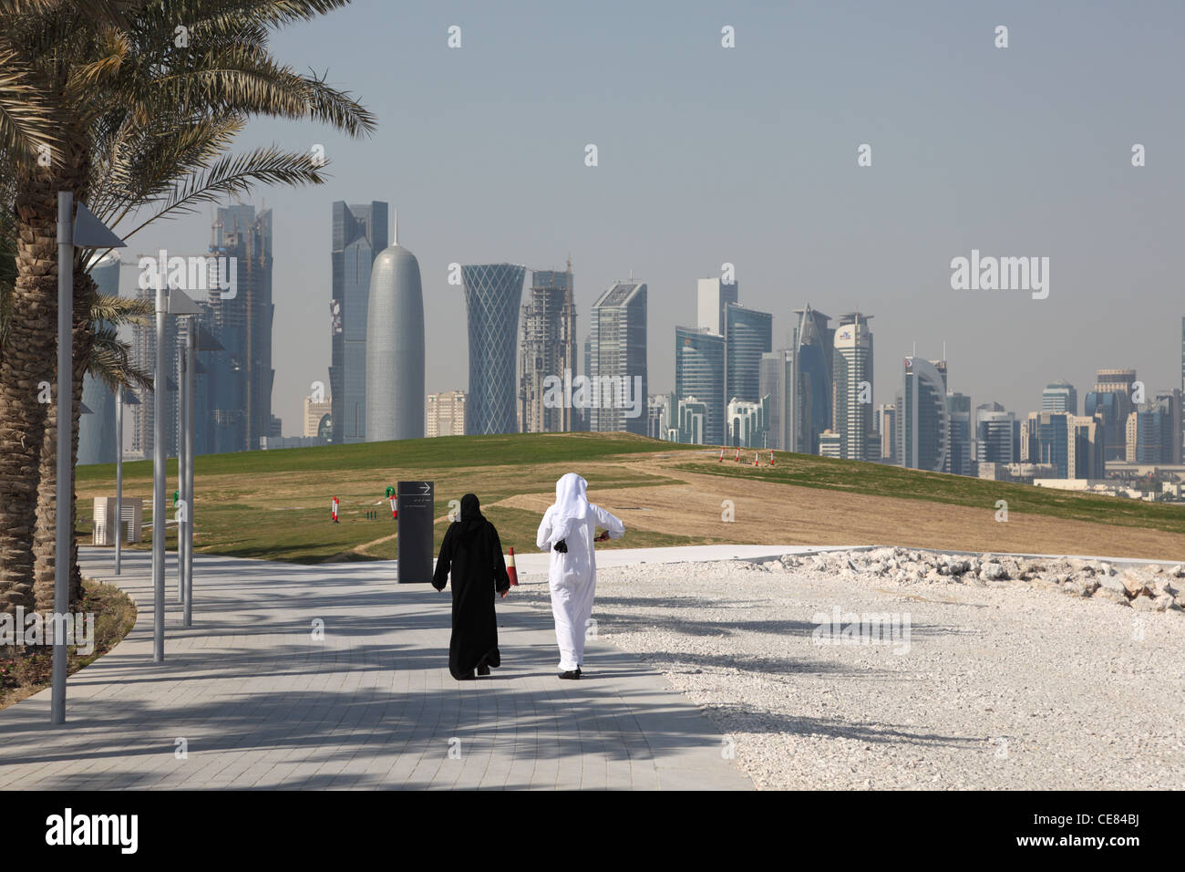Arabic couple walking in front of Doha skyline, Qatar Stock Photo - Alamy