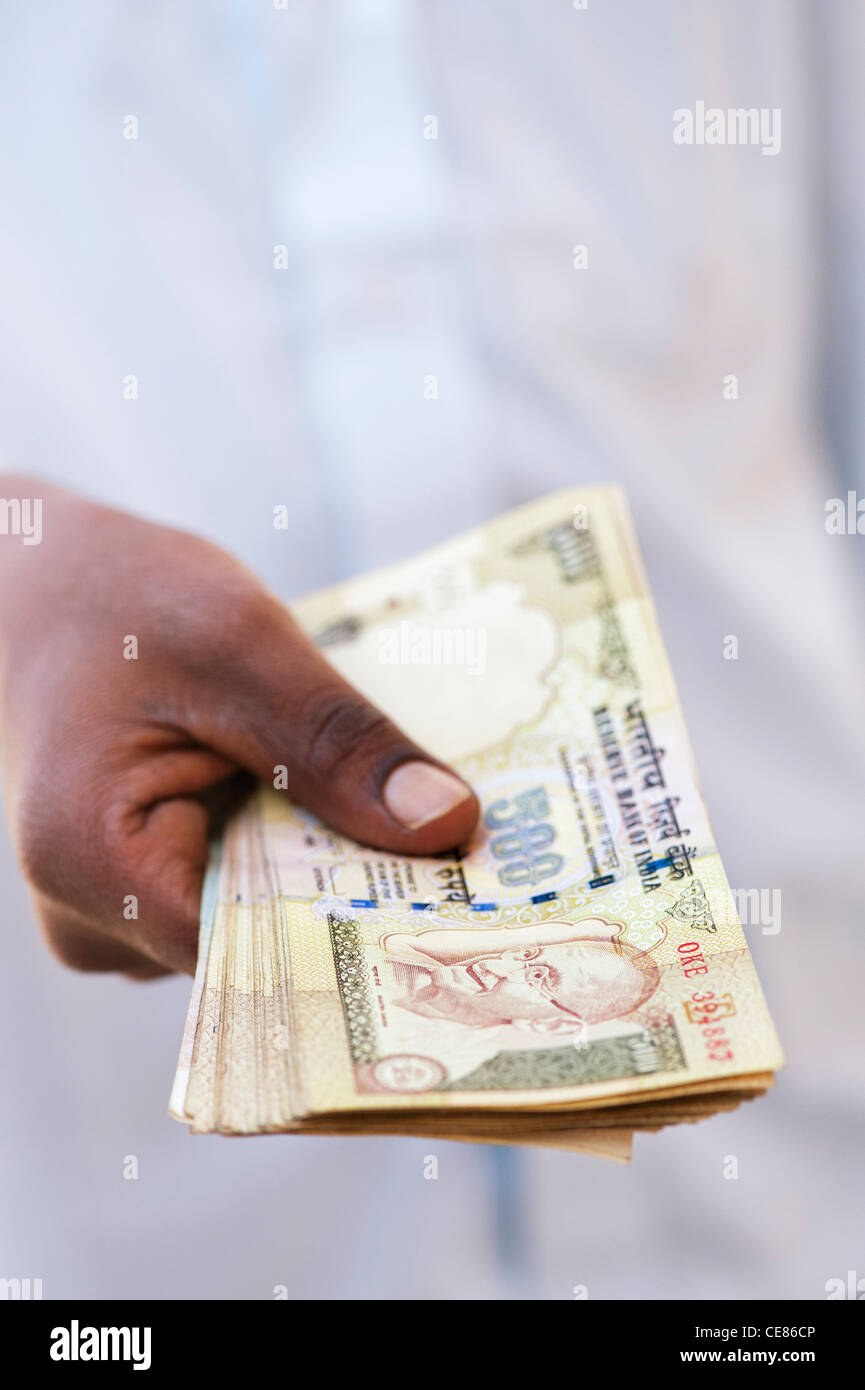Indian mans hand holding a bunch of 500 rupee notes which were ...