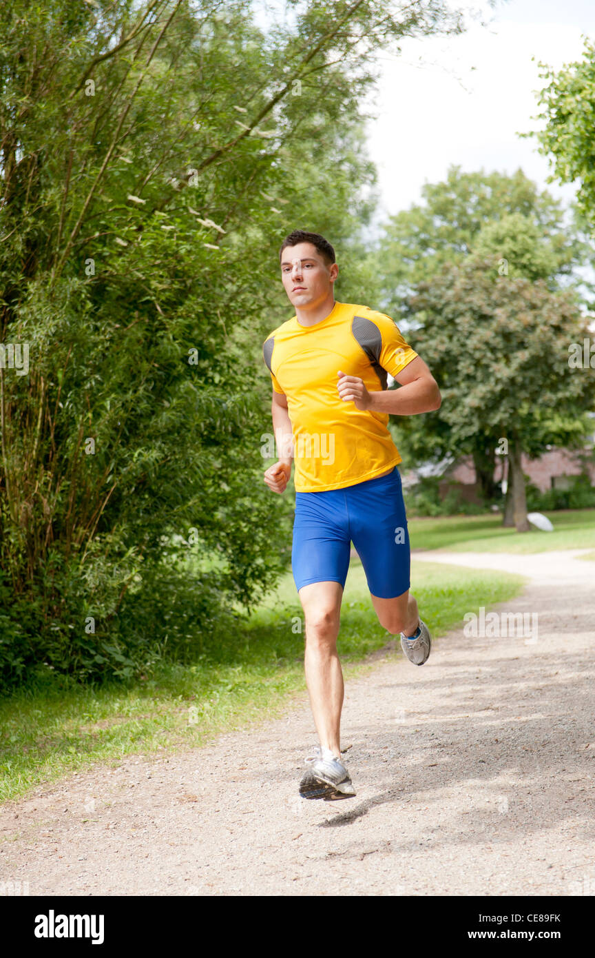 Young and smiling jogger in the park Stock Photo - Alamy