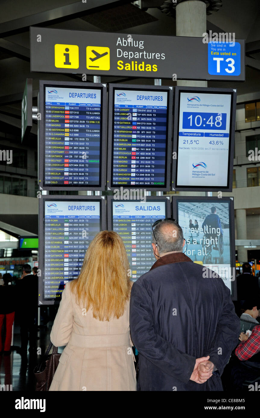 Passengers looking at departure destination boards in Terminal 3 ...