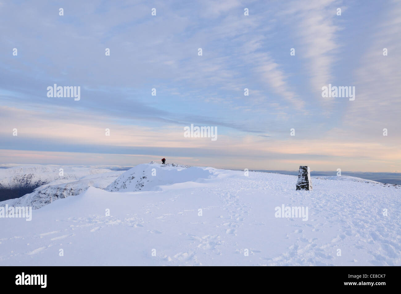 Helvellyn summit trig point at dusk with lingering walkers in the ...