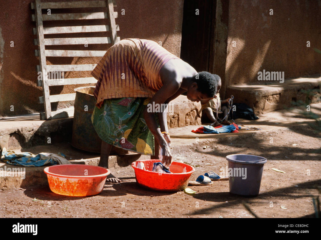 Mother washing clothes and a plastic bowl in rural Rwanda, Africa Stock ...