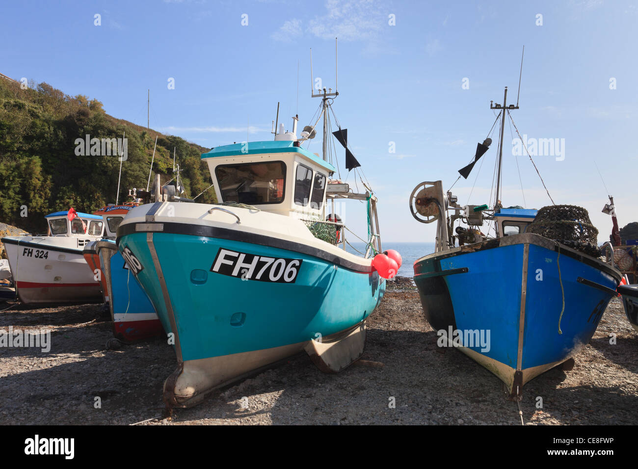 Cadgwith, Cornwall, England, UK. Fishing boats on shore in harbour on ...
