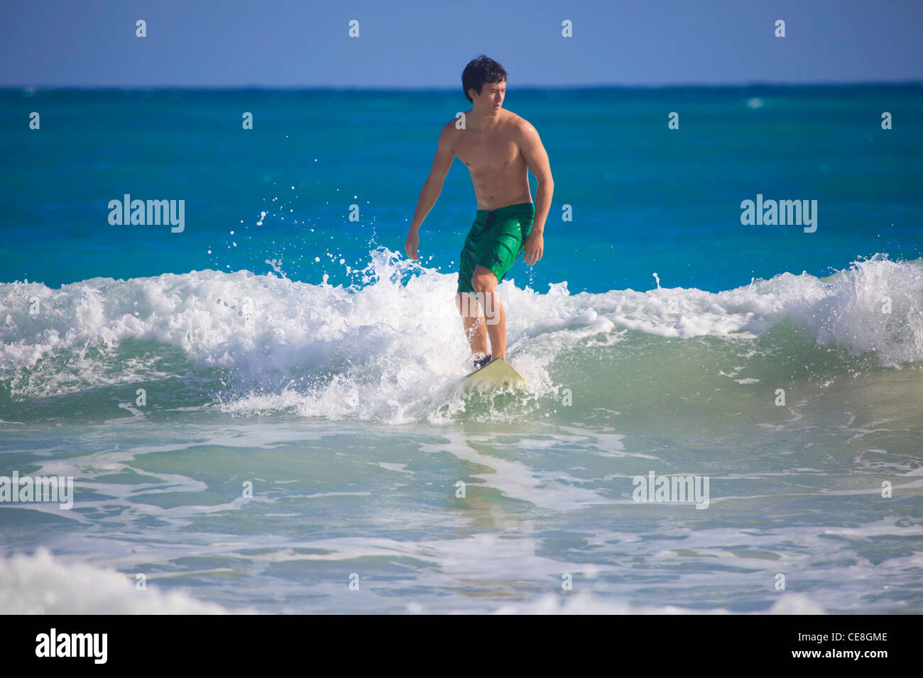 young asian american man surfing in hawaii Stock Photo - Alamy