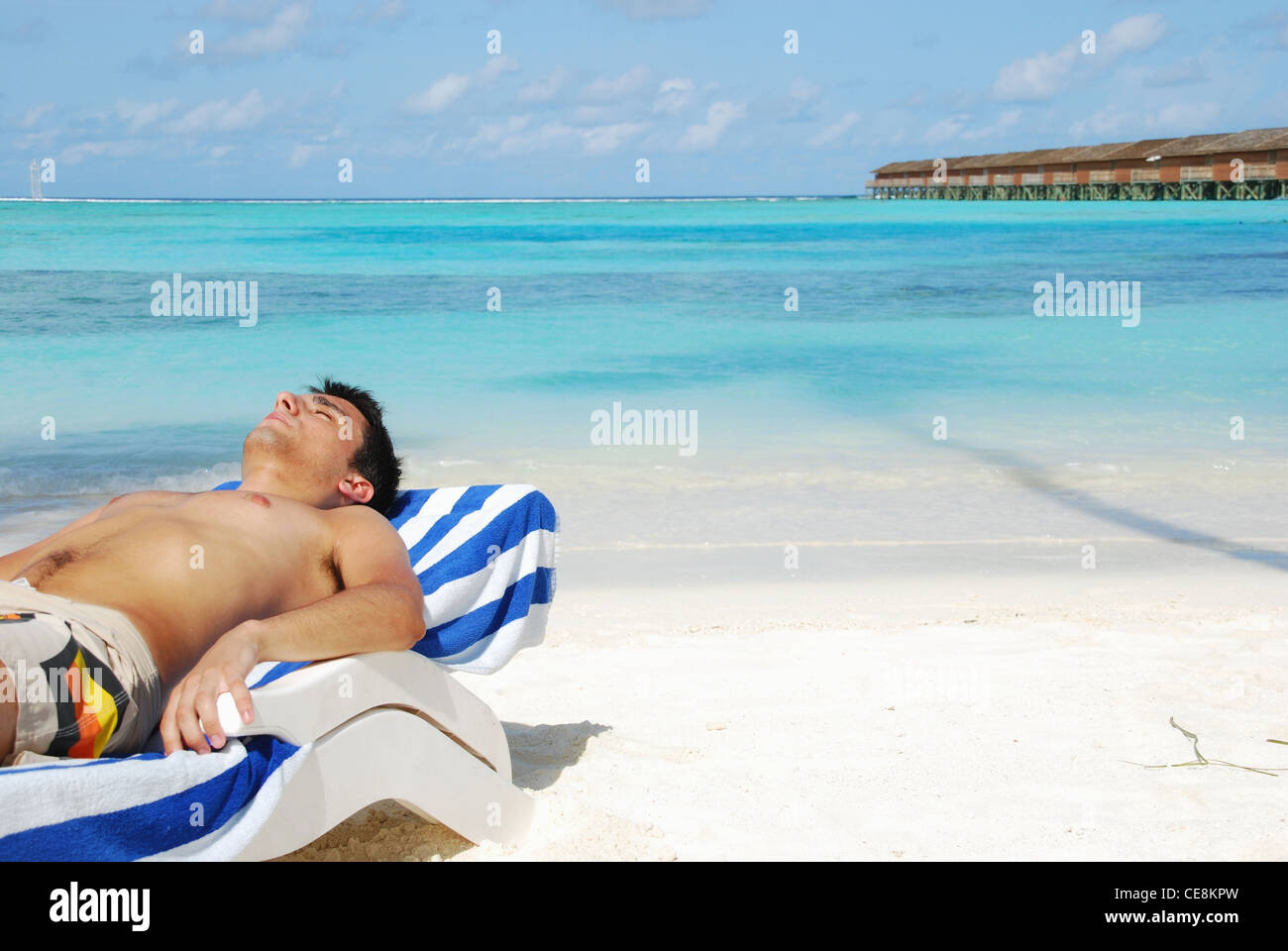 Young man sunbathing in Maldives Stock Photo - Alamy