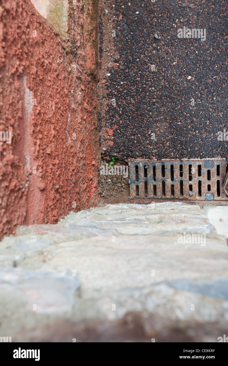The edge of a linear surface water drain abutting wall Stock Photo - Alamy
