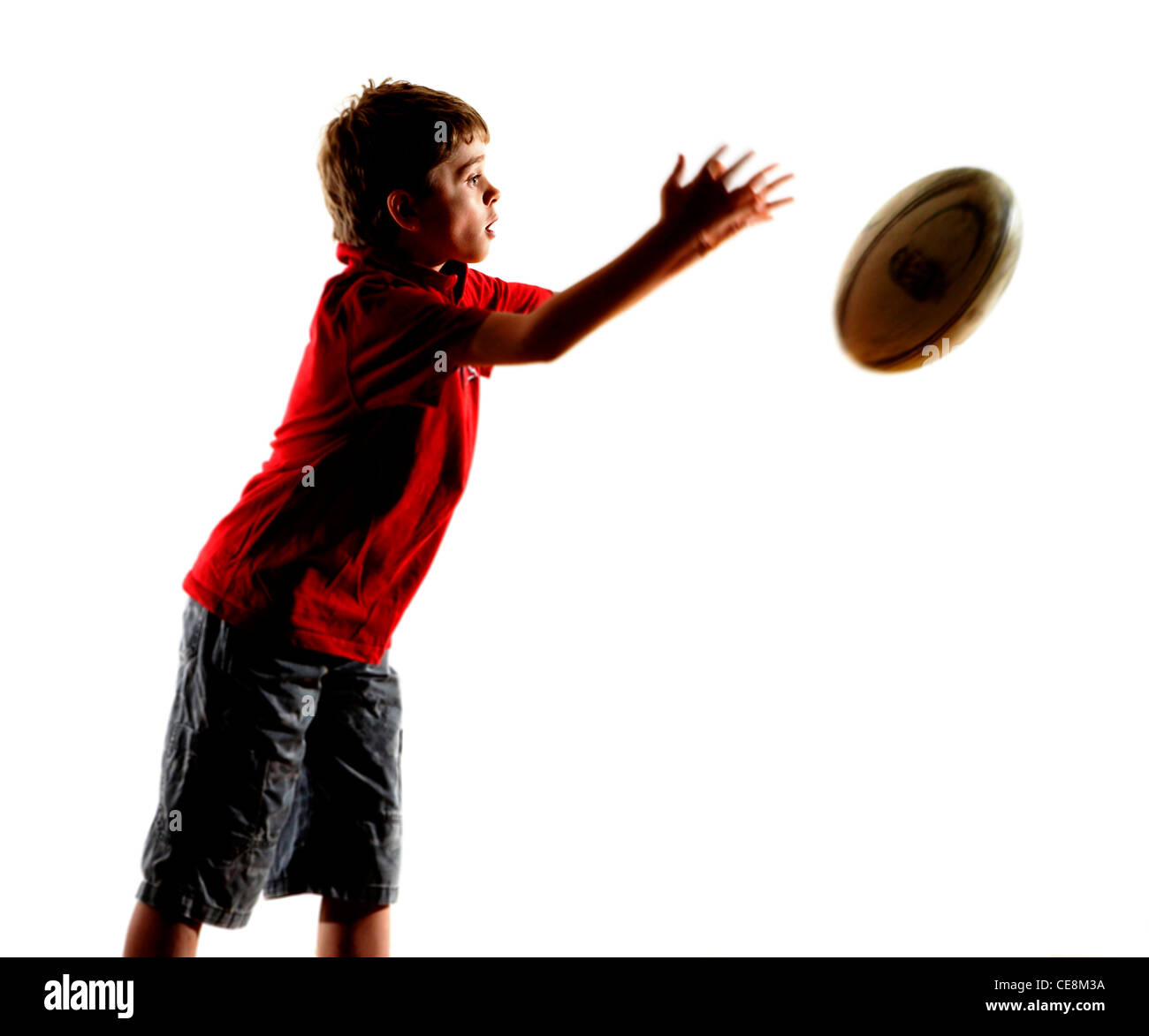 Young child (8) throw a rugby ball in the studio Stock Photo - Alamy