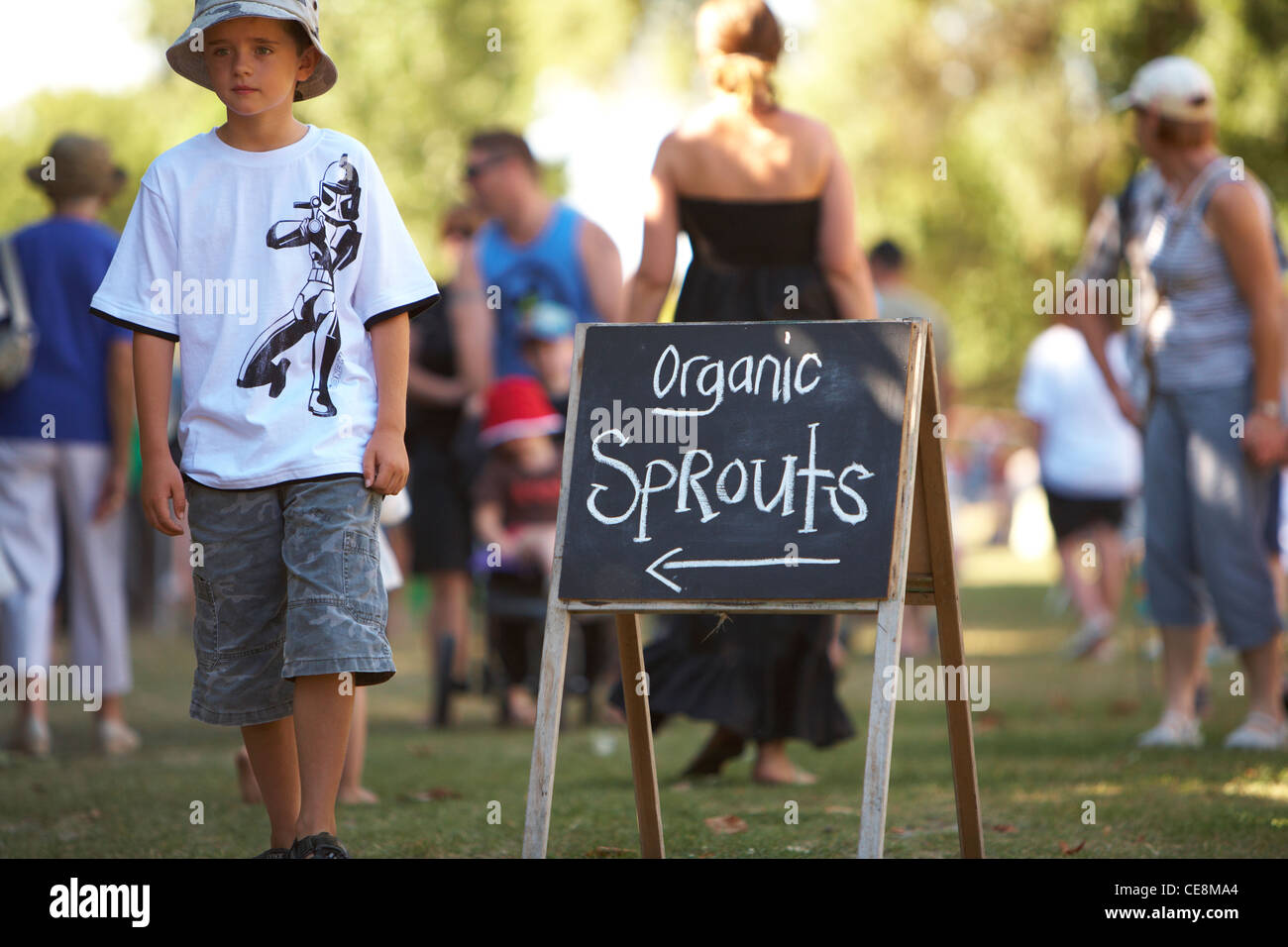 Boy walking through farmers market next to organics sign Stock Photo ...