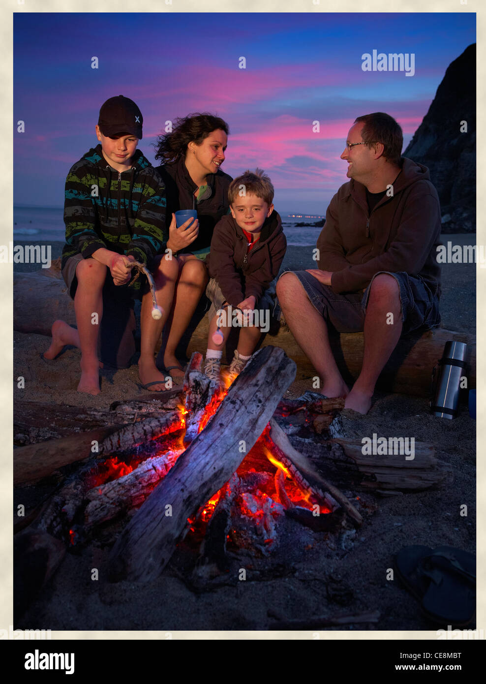 family by fire on the beach Stock Photo - Alamy