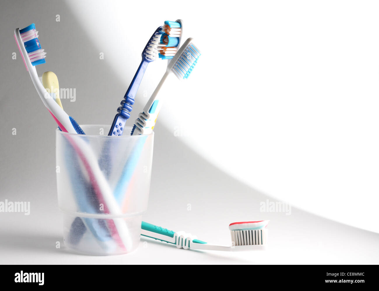 Some toothbrushes in a plastic glass Stock Photo - Alamy