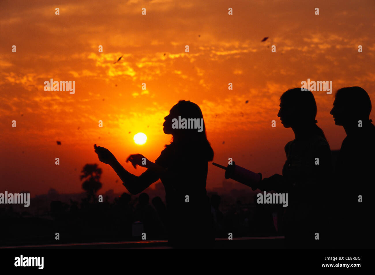 Kite festival ; Makar Sankranti ; Indian woman on terrace flying kite ...