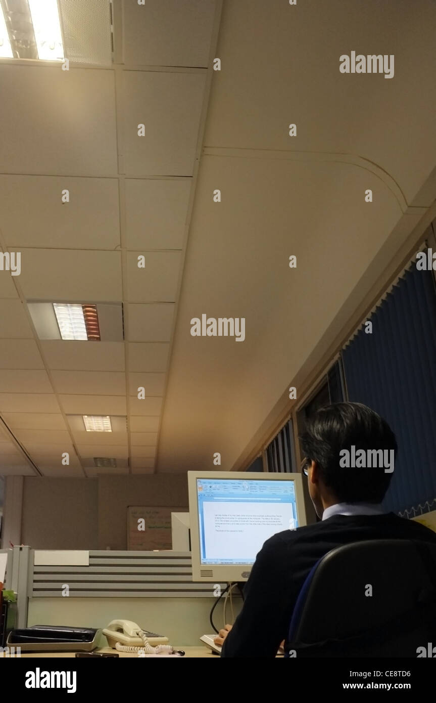 An office work sits at a computer, beneath energy saving movement ...