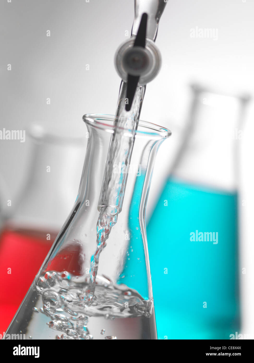 Laboratory glassware. Fluid being poured into a conical flask Stock ...