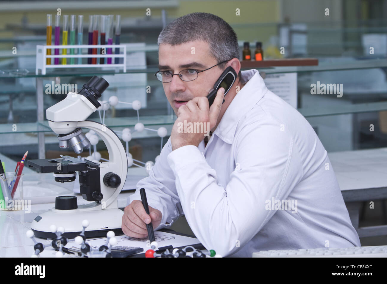 A male researcher using a mobile phone at his workplace in the ...