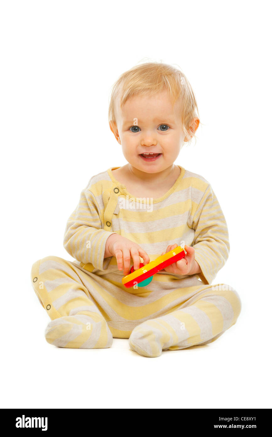 Adorable baby sitting on floor and playing with rattle isolated on ...