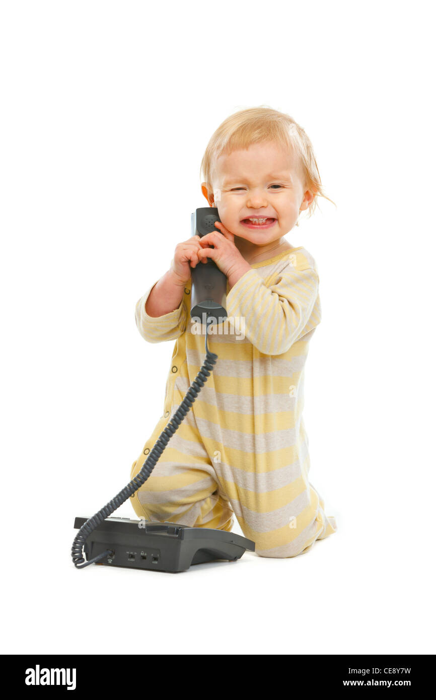Happy baby making funny face while playing with phone isolated on white ...