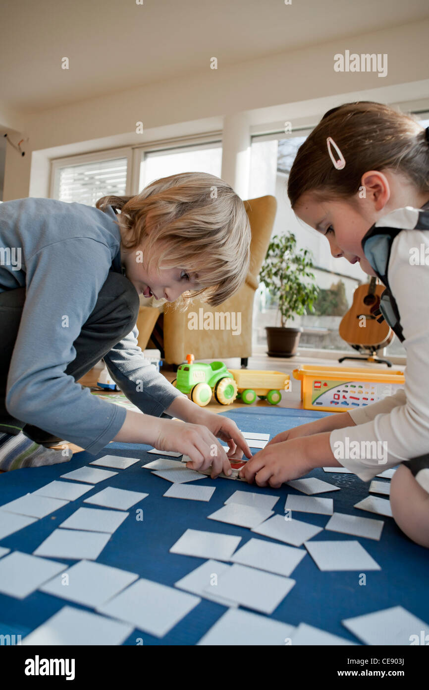 Two friends playing memory card game on the floor Stock Photo - Alamy