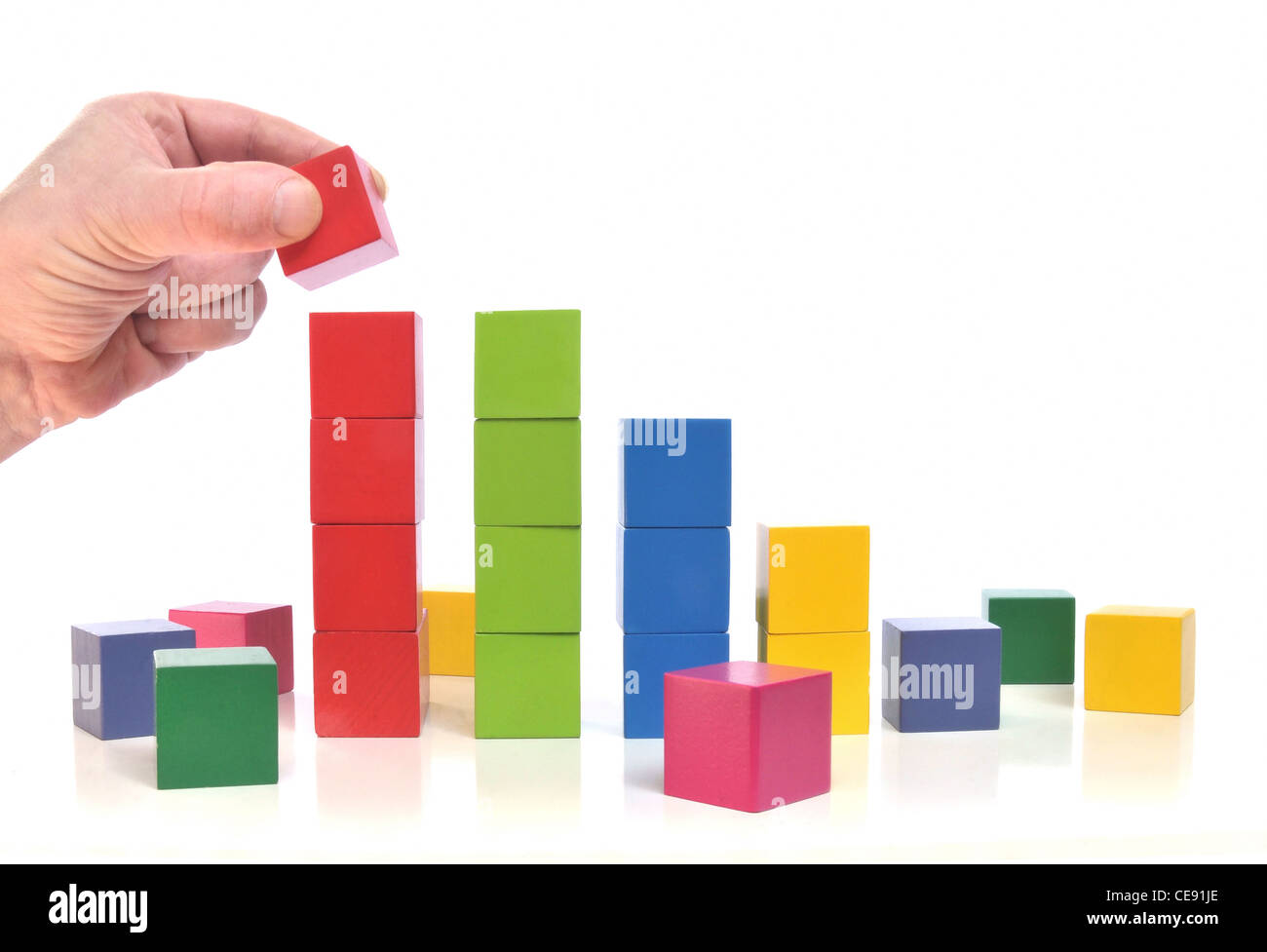 Human hand and multicolored toy blocks on white background Stock Photo ...