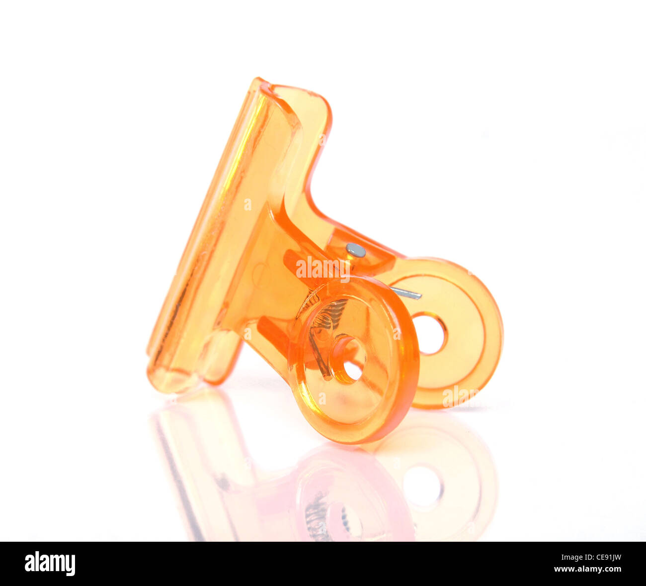 Orange colored office paper clip on white background Stock Photo - Alamy