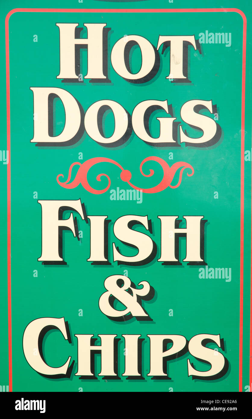 Green wooden sign with Hot Dogs and Fish and Chips sign written on it ...