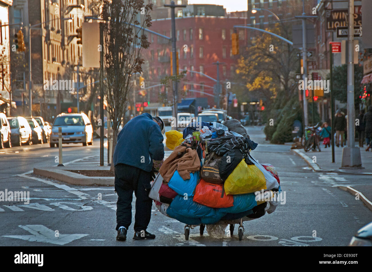 Homeless man pushing trolley with his belongings through lower ...