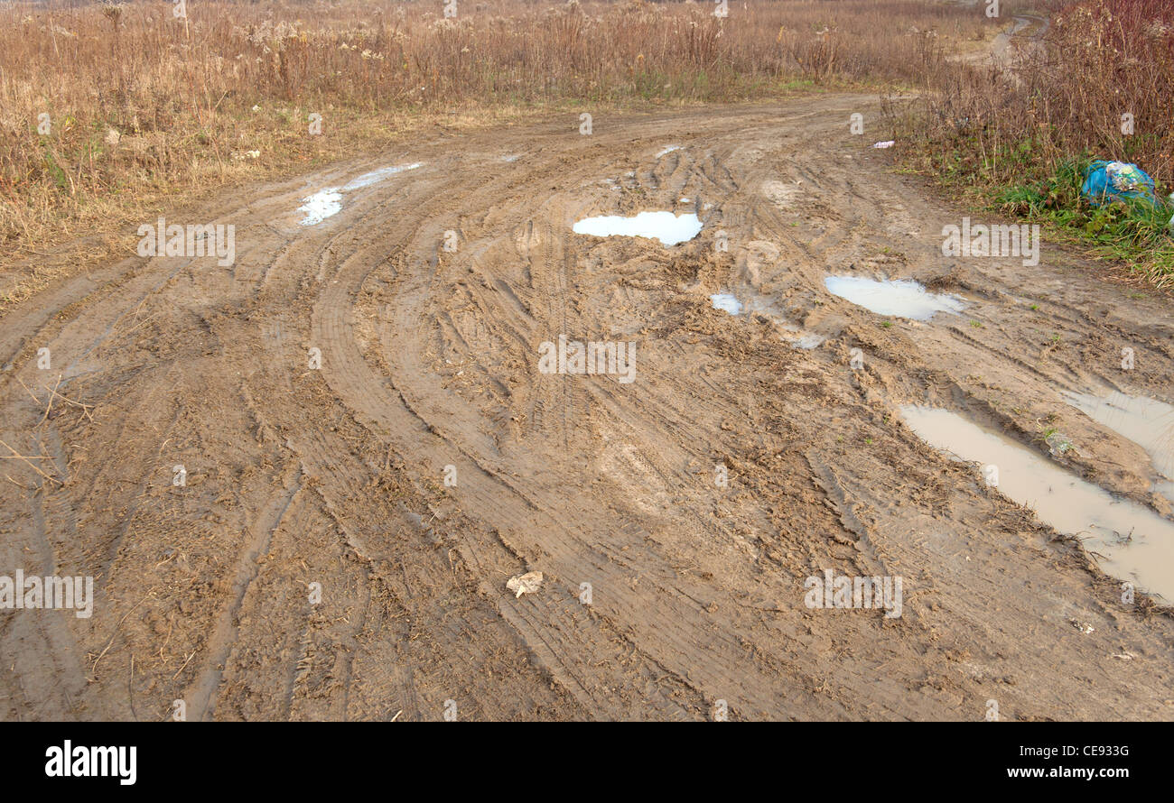 Traces of car tyres on the wet fields road Stock Photo - Alamy