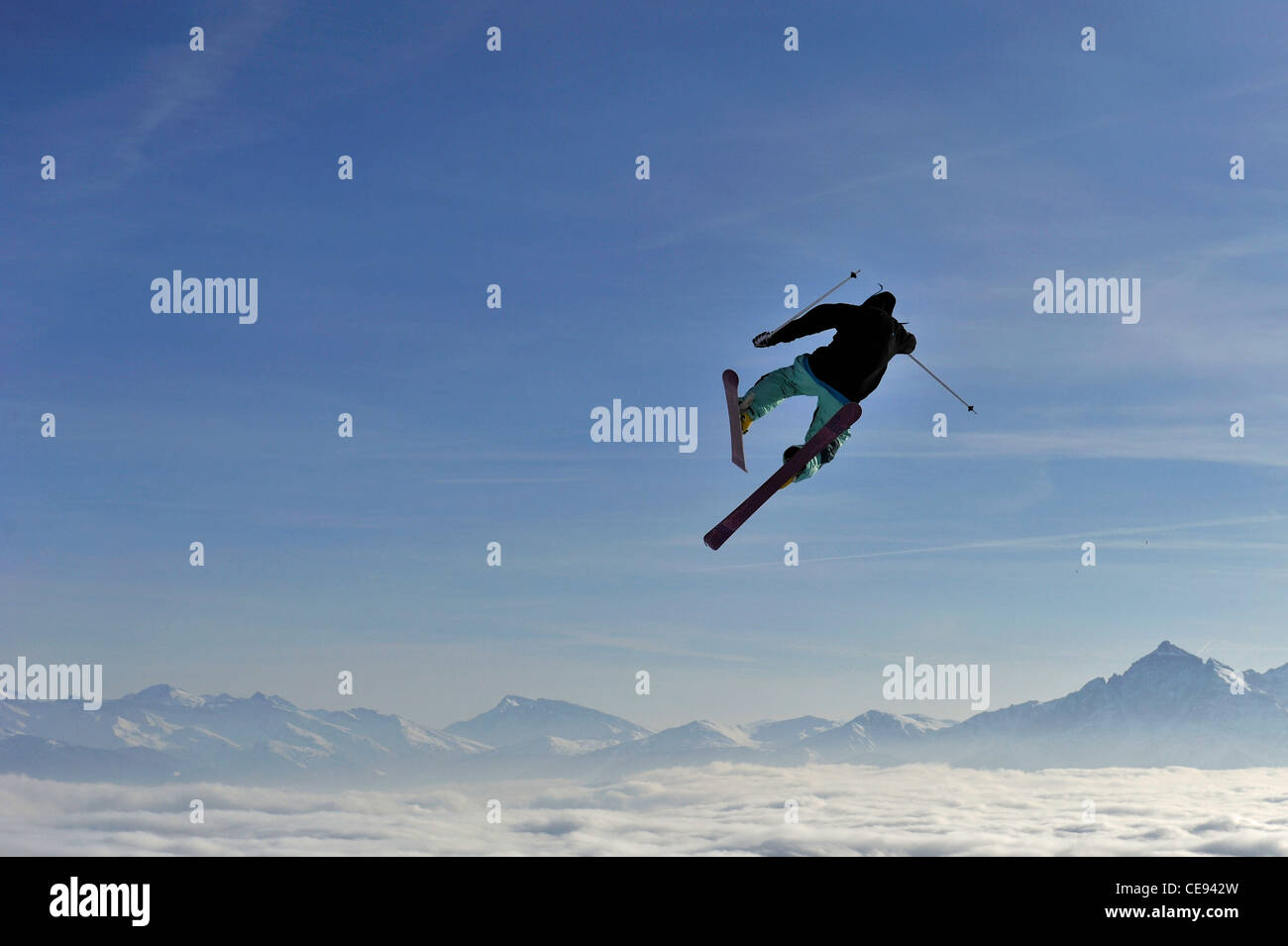 A freestyle skier jumps through the air performing tricks above the sea ...