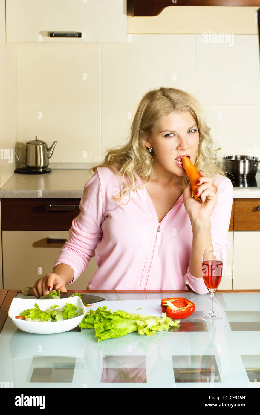 sad young woman at home in the kitchen keeping a diet and eating ...