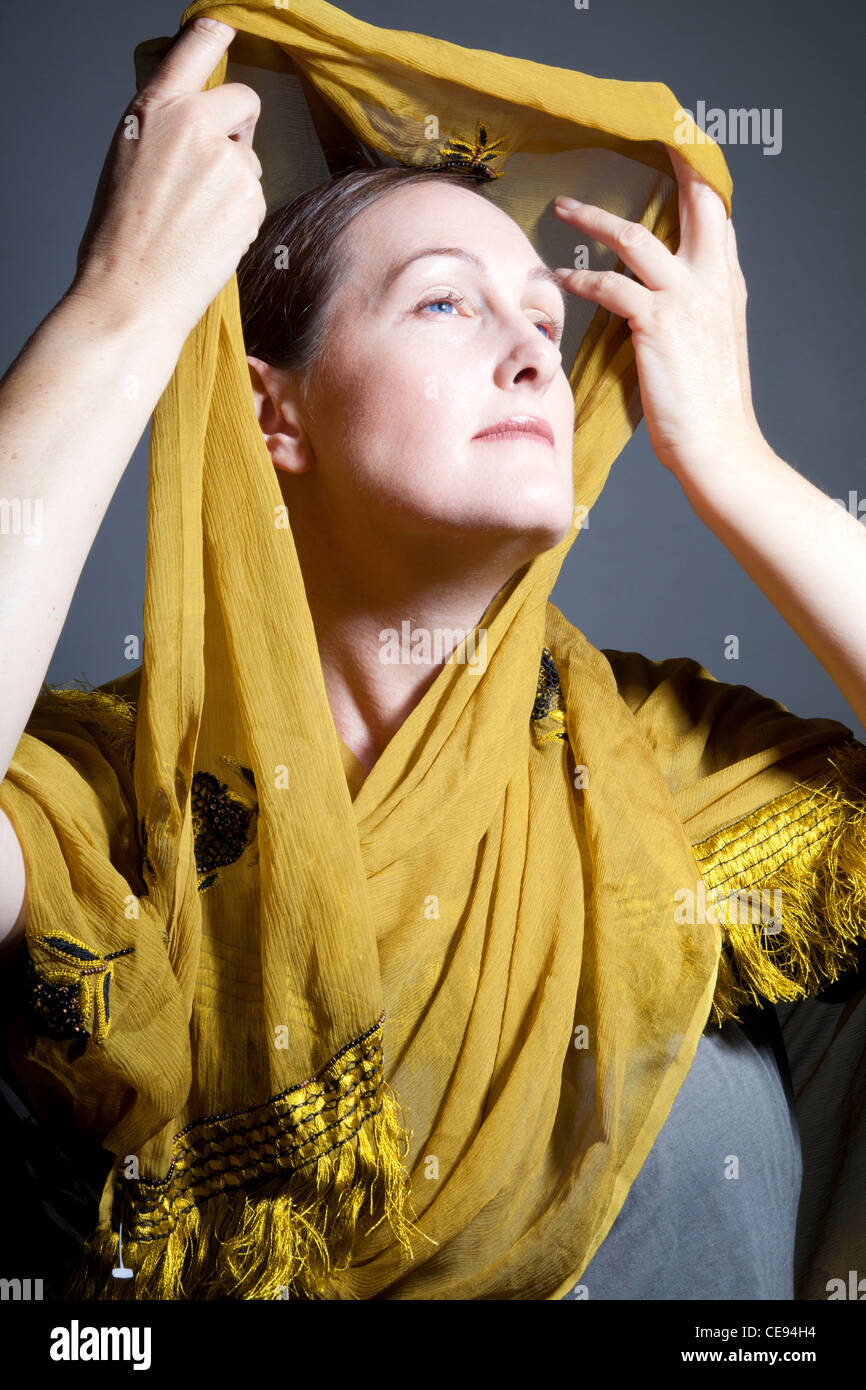 Woman Placing Yellow Shawl Stock Photo - Alamy