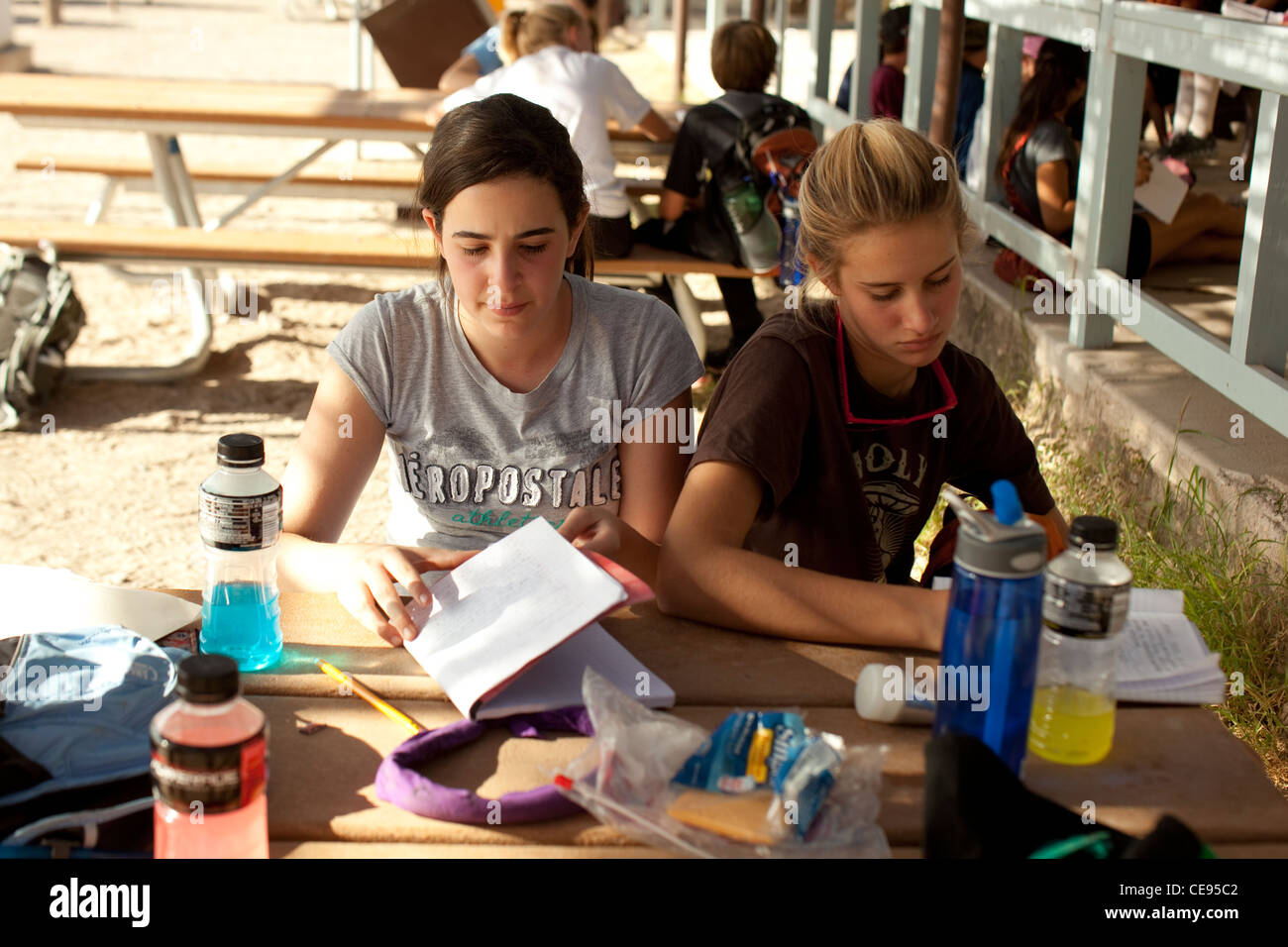 Middle school age students hand write reports during school camping ...