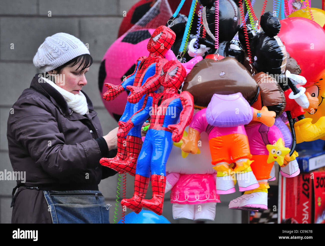 A market trader tends her stall of inflatable toys Stock Photo - Alamy