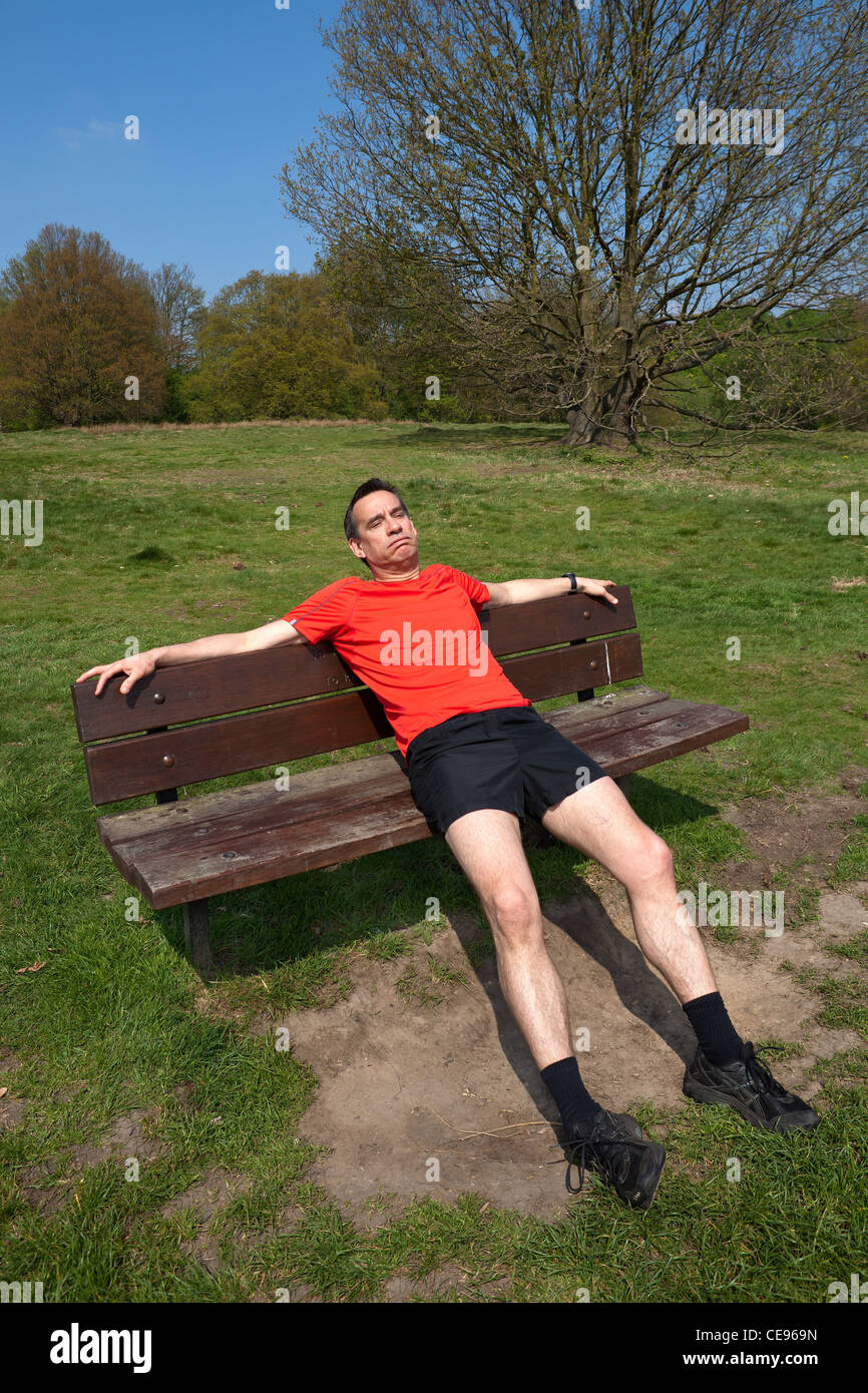 Tired man exercising Resting exhausted on Sunny Park Bench Stock Photo ...