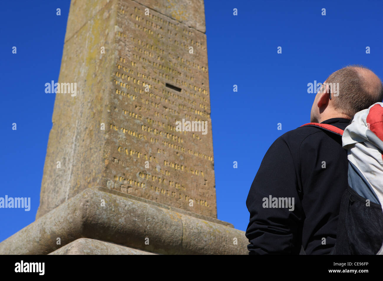 Man reading the inscription on a sandstone memorial Stock Photo - Alamy