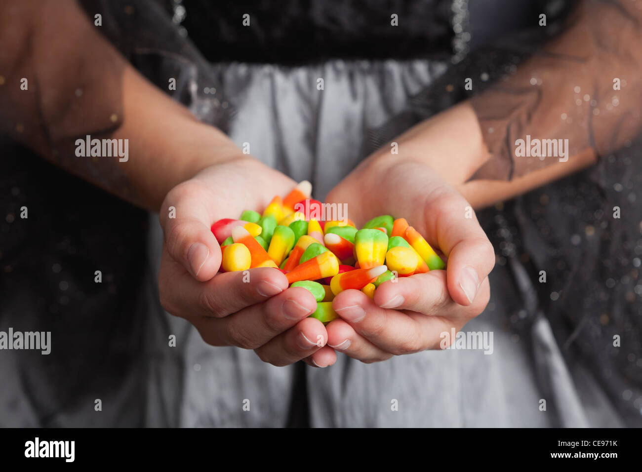 Midsection of teen girl holding handful of candies Stock Photo - Alamy