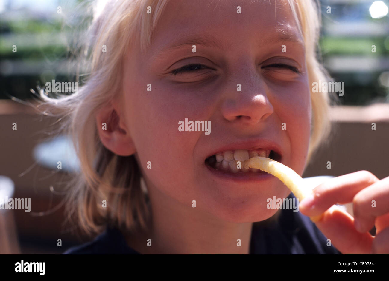 Child age 7 eating chips Stock Photo - Alamy