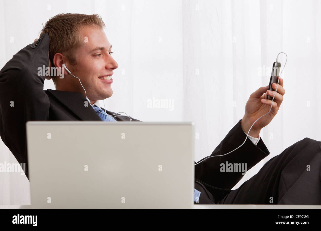 Studio shot of businessman listening to mp3 player Stock Photo - Alamy
