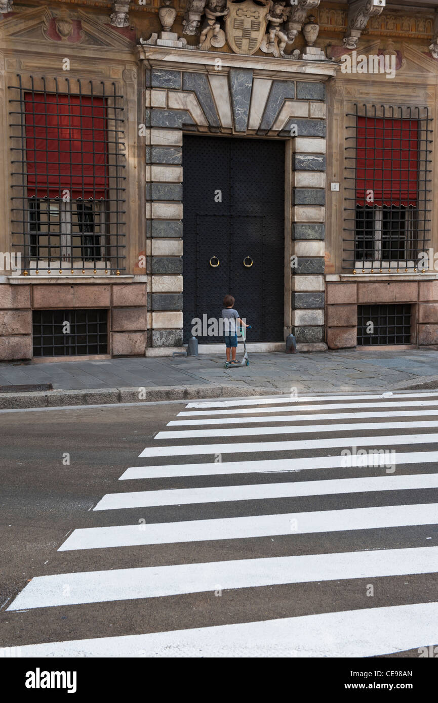 A small boy on a scooter outside Palazzo Paolo Battista Nicolò ...
