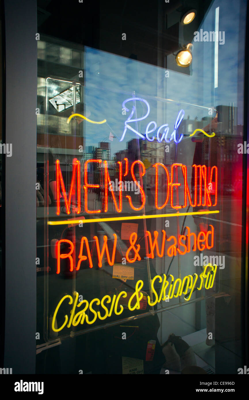 A store in New York advertises its denim with a neon sign in the window ...