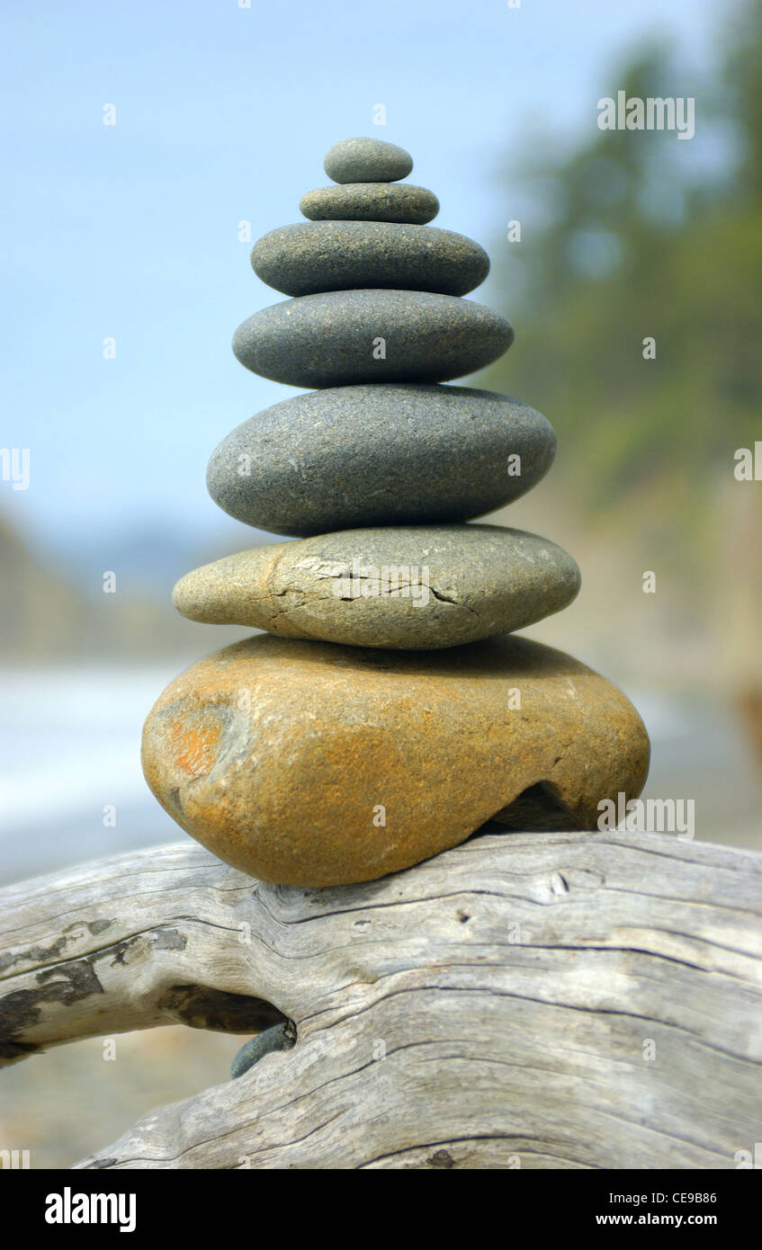 Conical stones balanced on a weathered tree Stock Photo - Alamy
